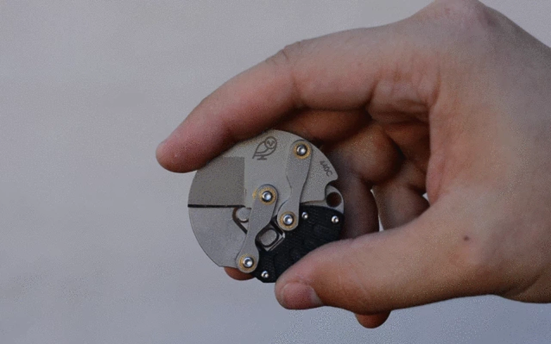 Coin-shaped pocket knife snaps into action