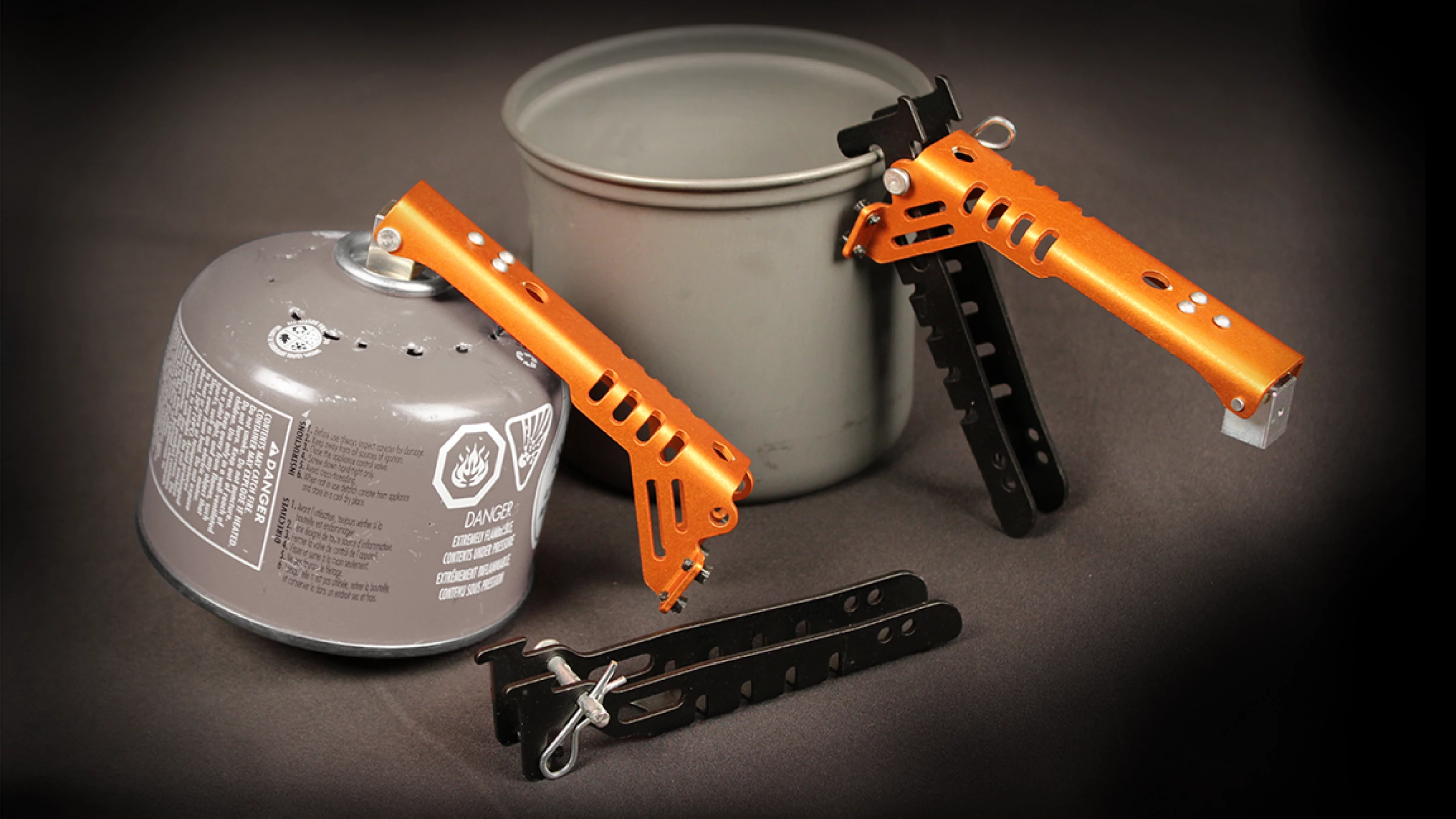 Camp pot gripper also punctures fuel canisters for safe recycling