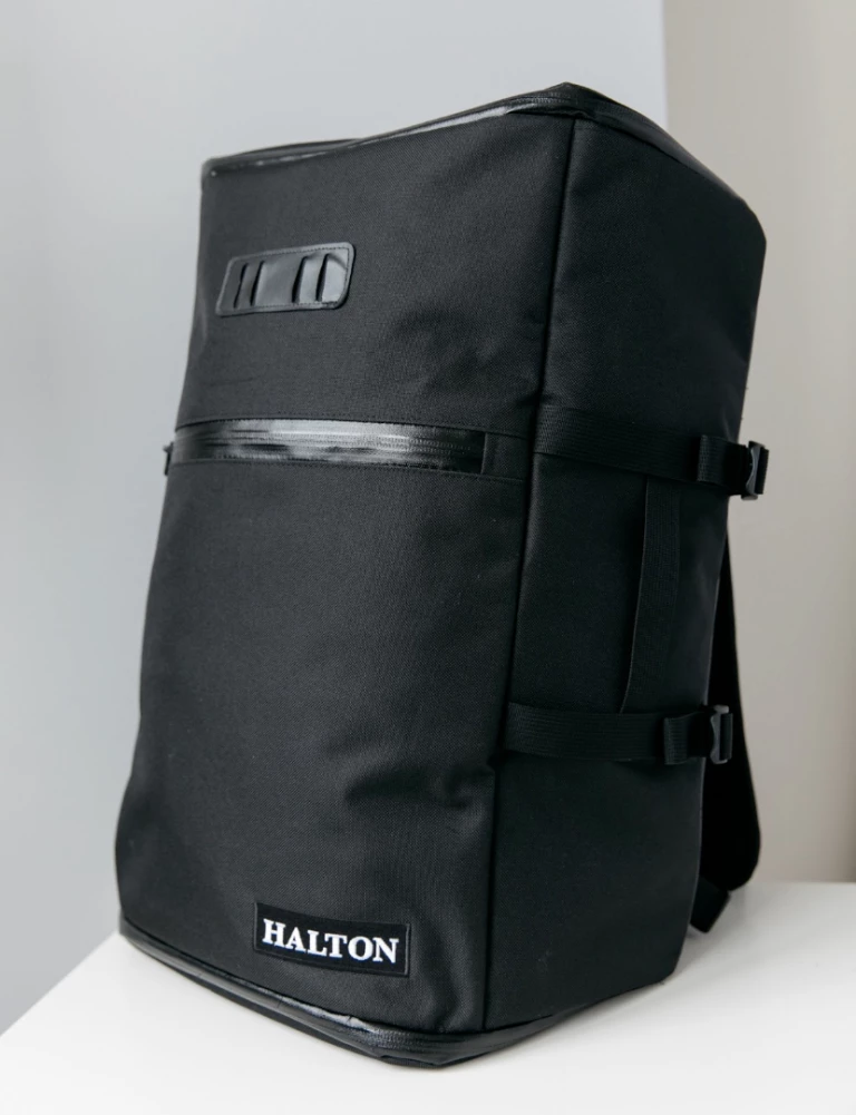 Commuter backpack unfurls into a hanging organizer via a single zip