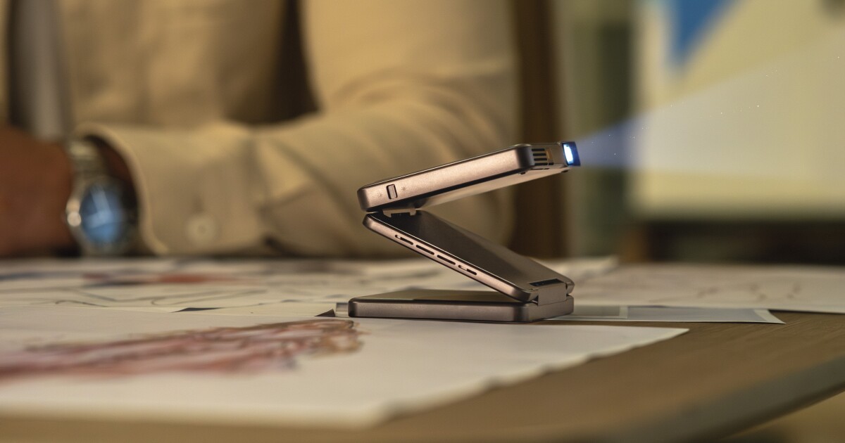 Portable mini projector stands on its own with tri-fold hinge