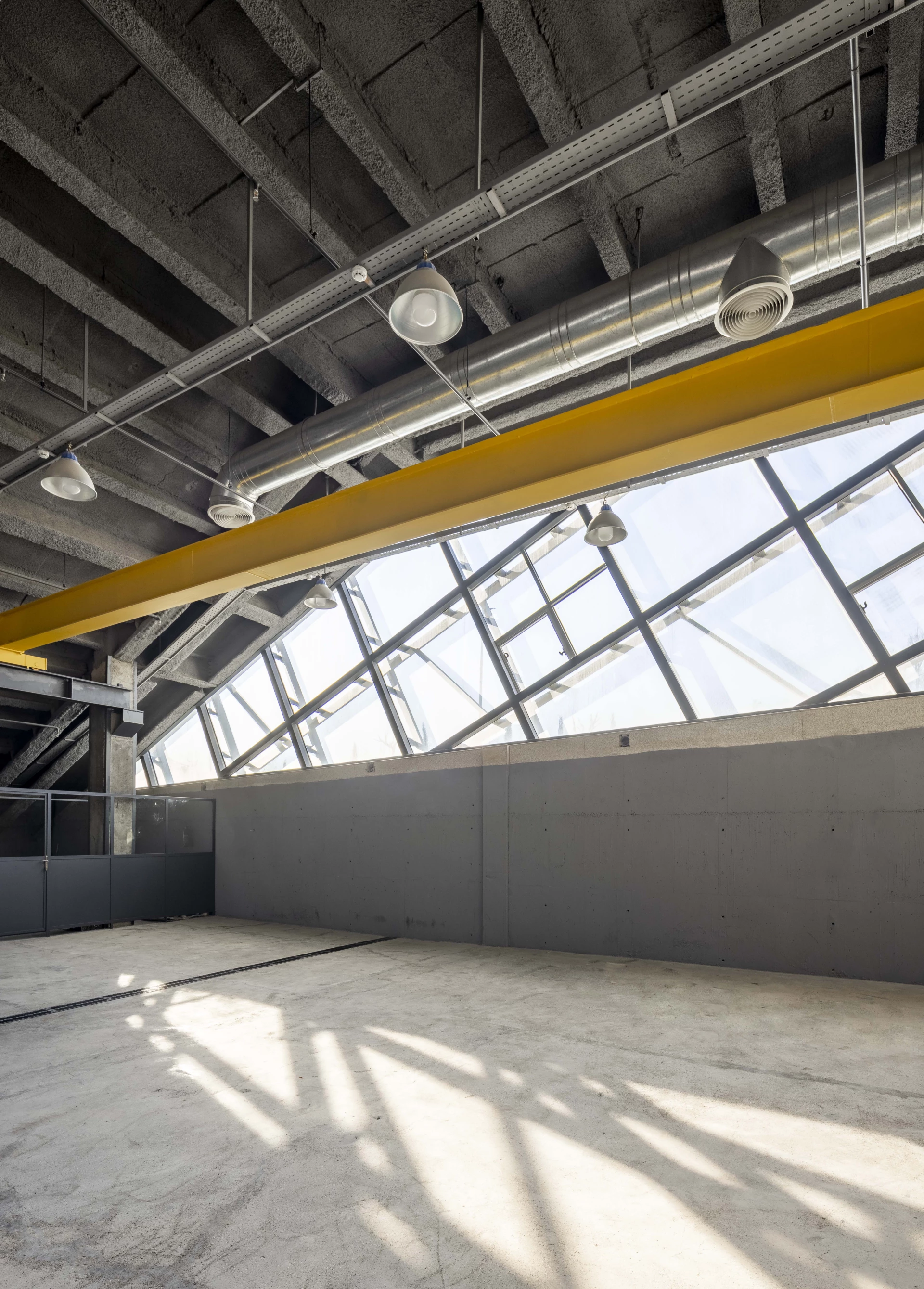 Glazed office rises out of the ground with a dramatic tilting form