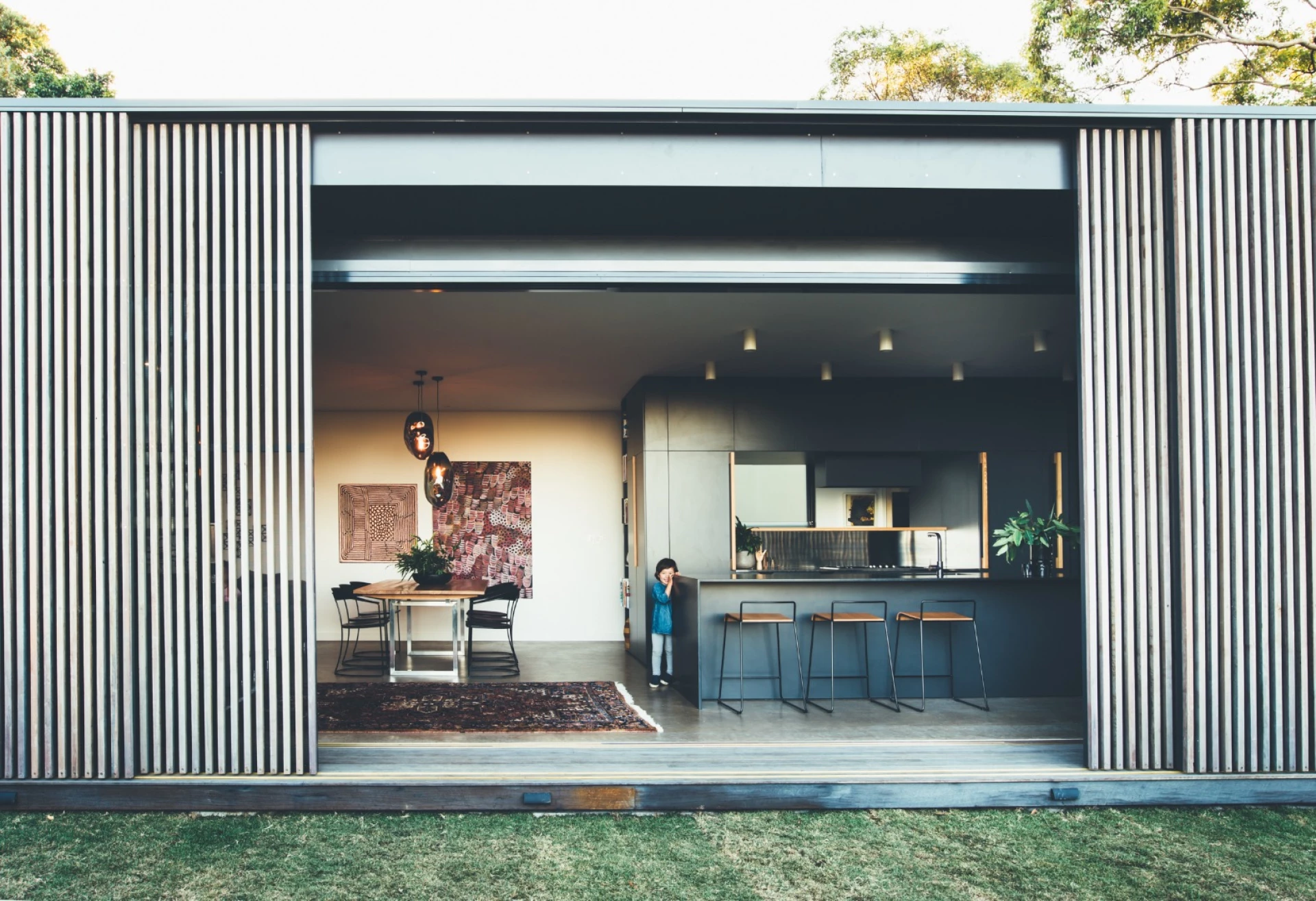 Timber screens shield glass house from summer sun