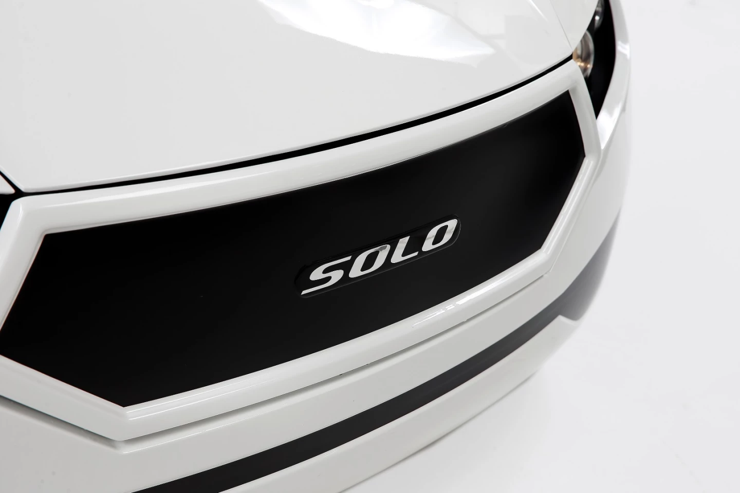 Three-wheeled Solo electric vehicle motors past Elio on way to market