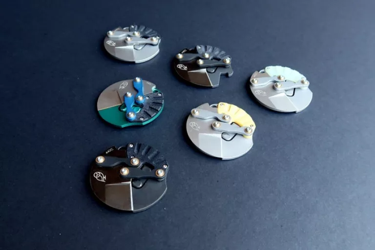 Coin-shaped pocket knife snaps into action