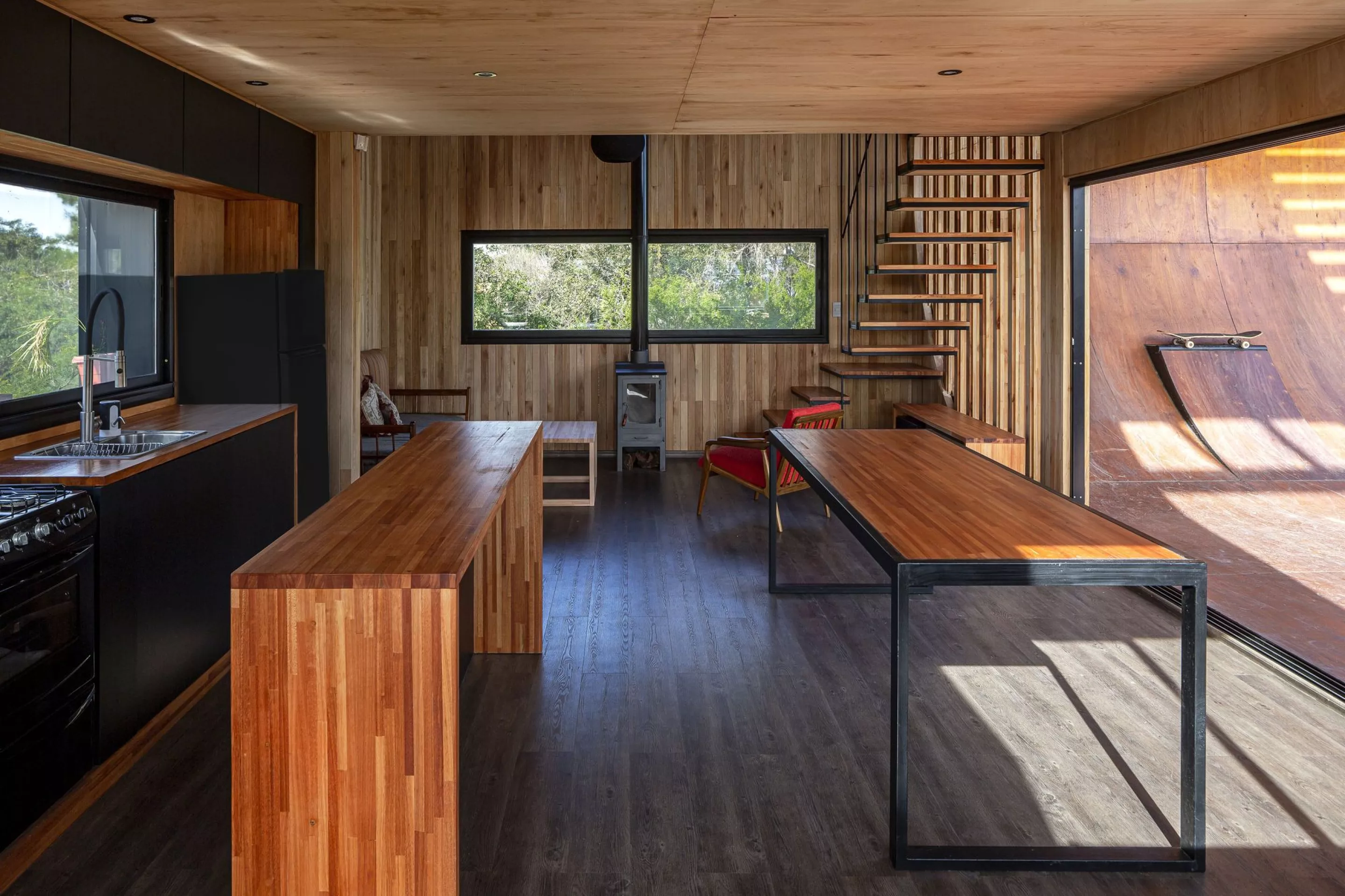 Stilted off-grid house carves its own niche with built-in skateboard ramp